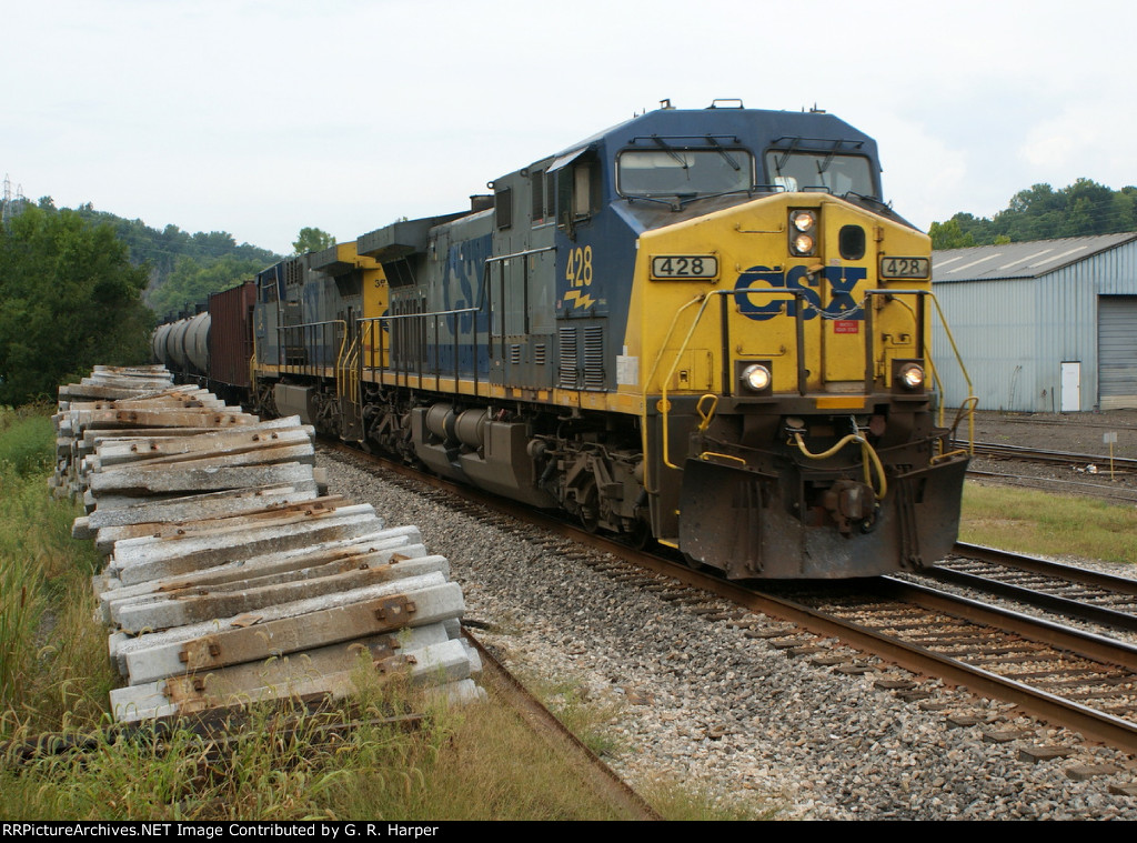 Oil train K082?? with CSXT 428 passes one of the piles of concrete ties still awaiting final ...
